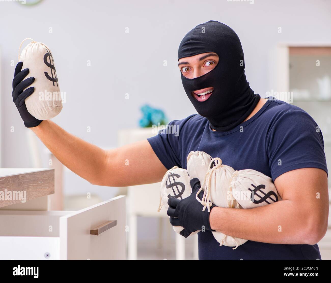Robber wearing balaclava stealing valuable things Stock Photo - Alamy