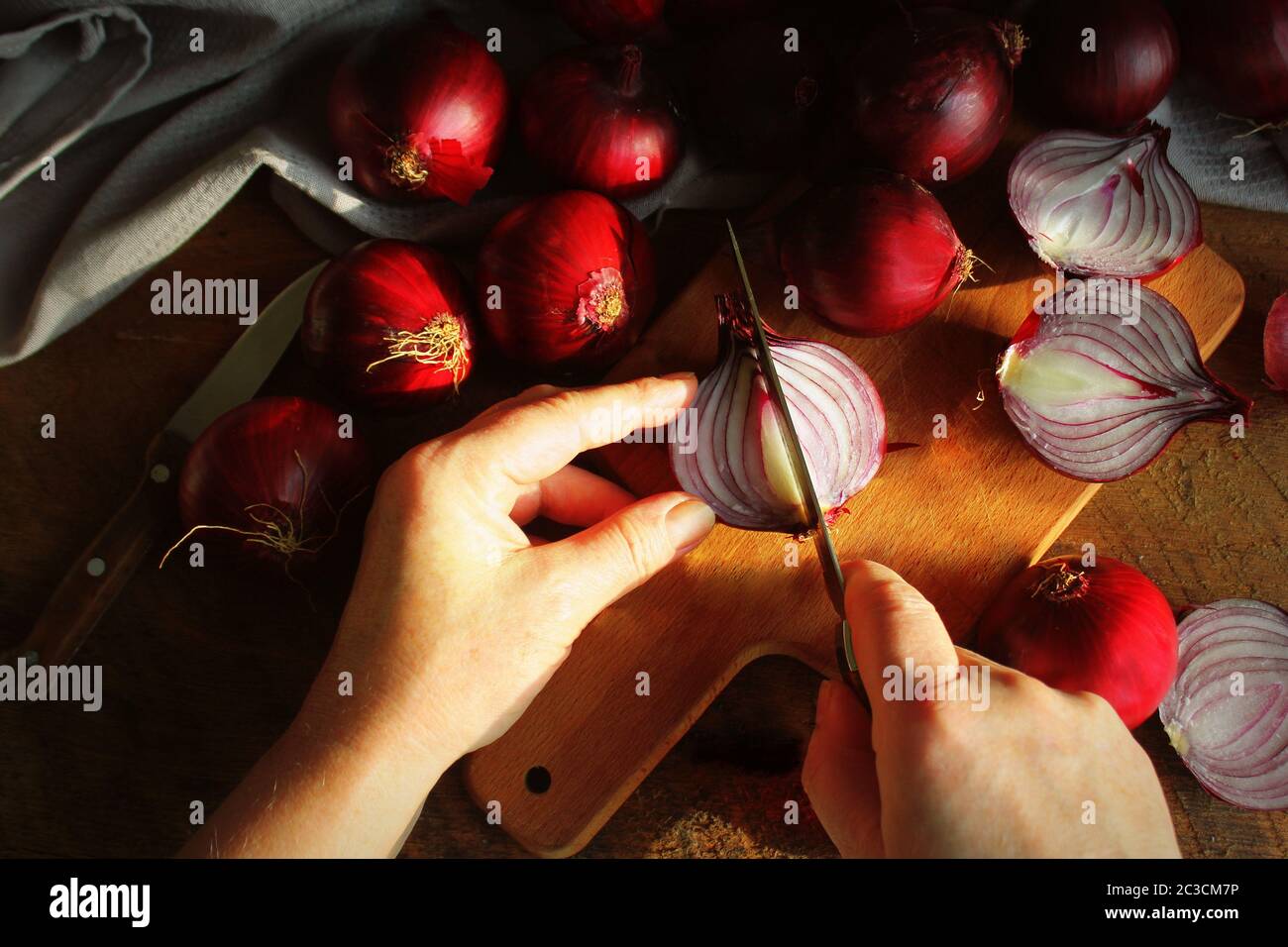 cutting red onions with knife on cutting board Stock Photo - Alamy