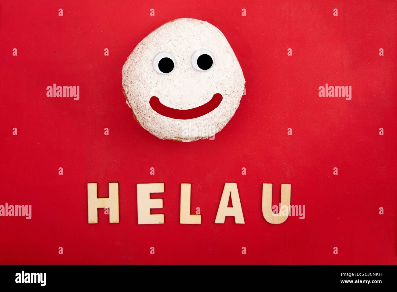 German Berliner Donut with funny eyes and text Helau Stock Photo - Alamy