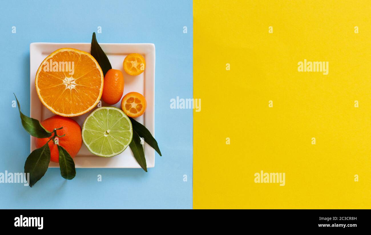 Citrus fruits on a blue and yellow background top view Stock Photo - Alamy