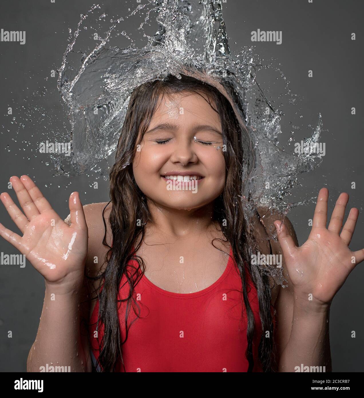 Teenage girl catching water stream from top Stock Photo - Alamy