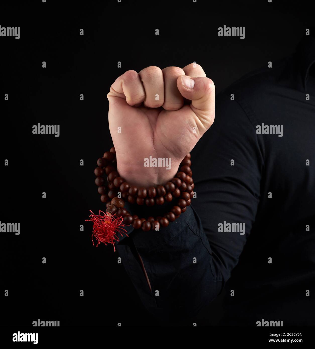 hand of an adult male shows Mushti Mudra on a dark background, clenched ...