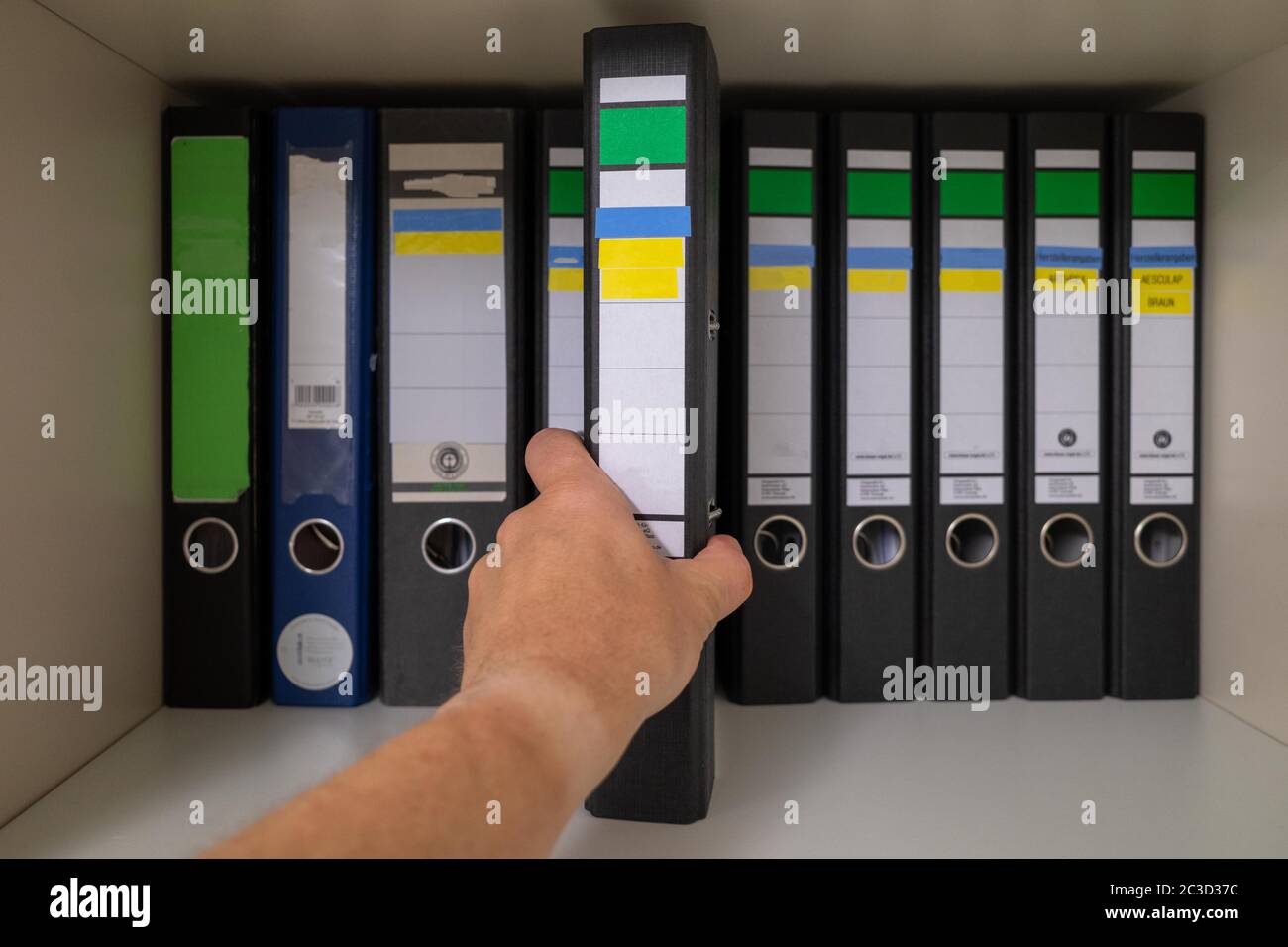 a file is taken out of a closet with many files Stock Photo - Alamy