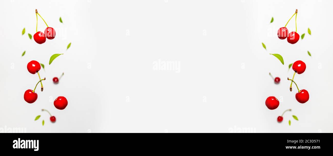 Falling fresh ripe cherries with green leaves frame isolated on white ...