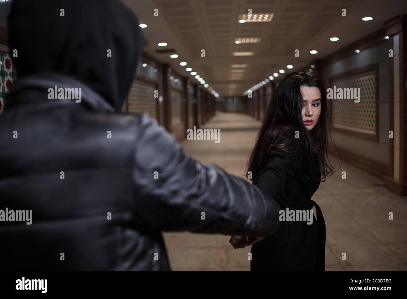 a young beautiful woman tries to escape from a robber in black clothes ...