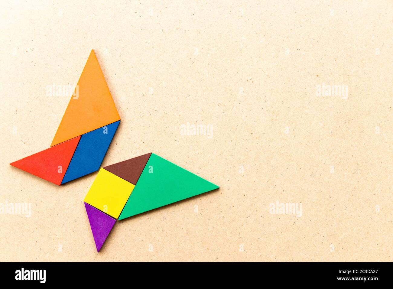 Color tangram puzzle in butterfly shape on wood background Stock Photo ...