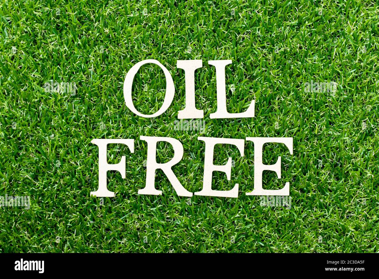 Wood alphabet letter in word oil freer on green grass background Stock ...