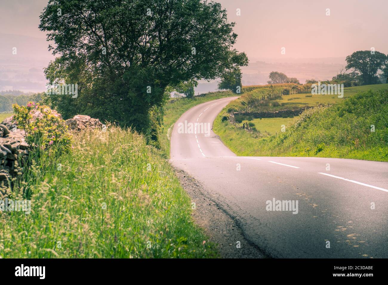 curved road in middle of rural Engalnd with dry stone walls Stock Photo ...