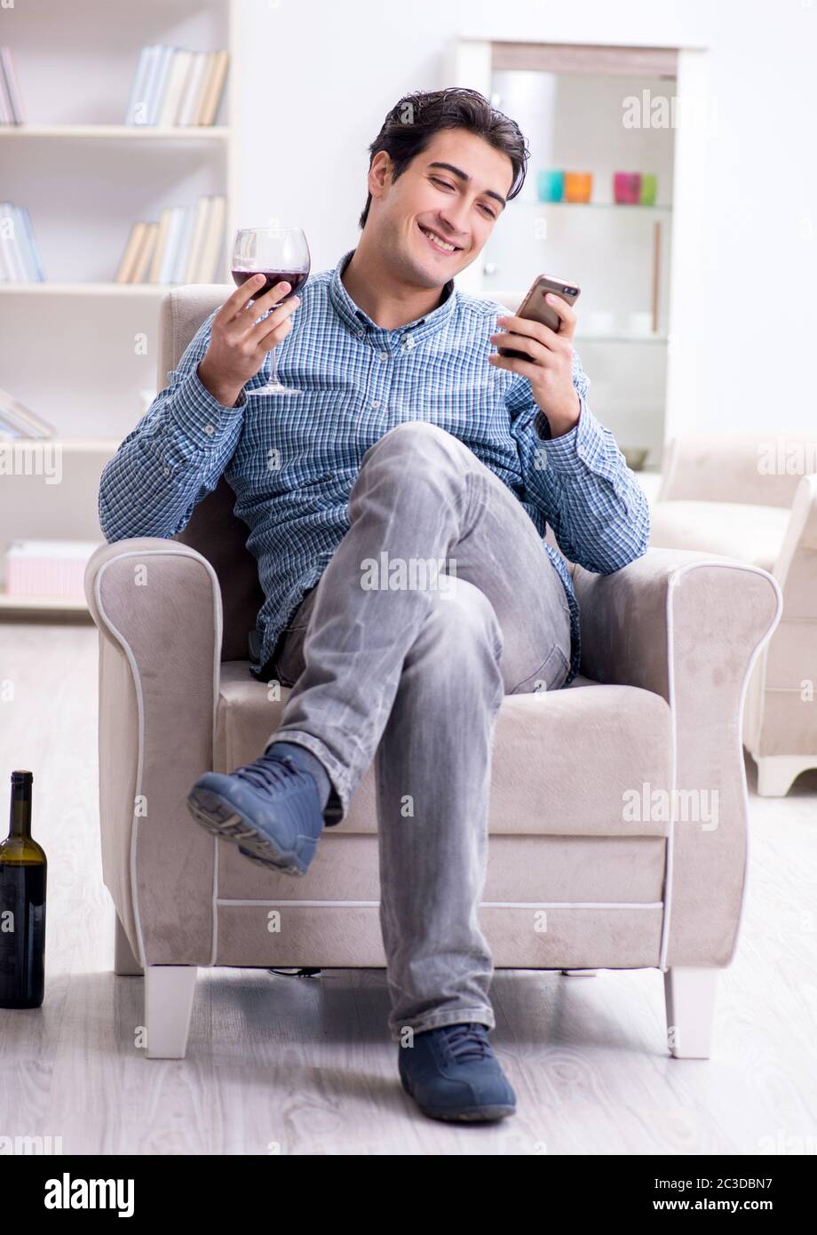 Young man drinking wine at home Stock Photo - Alamy