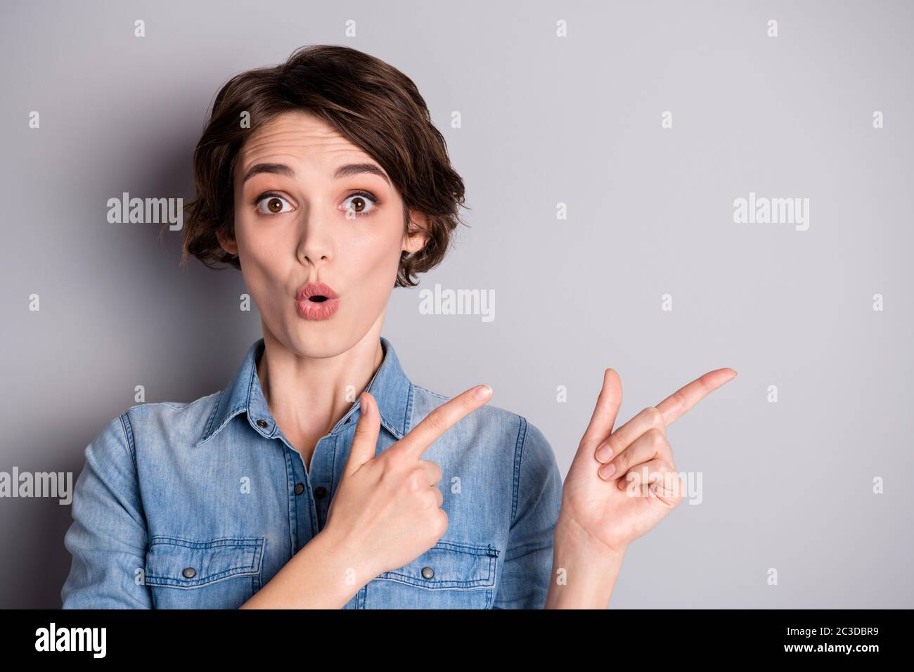 Portrait of astonished girl point index finger copyspace indicate ...