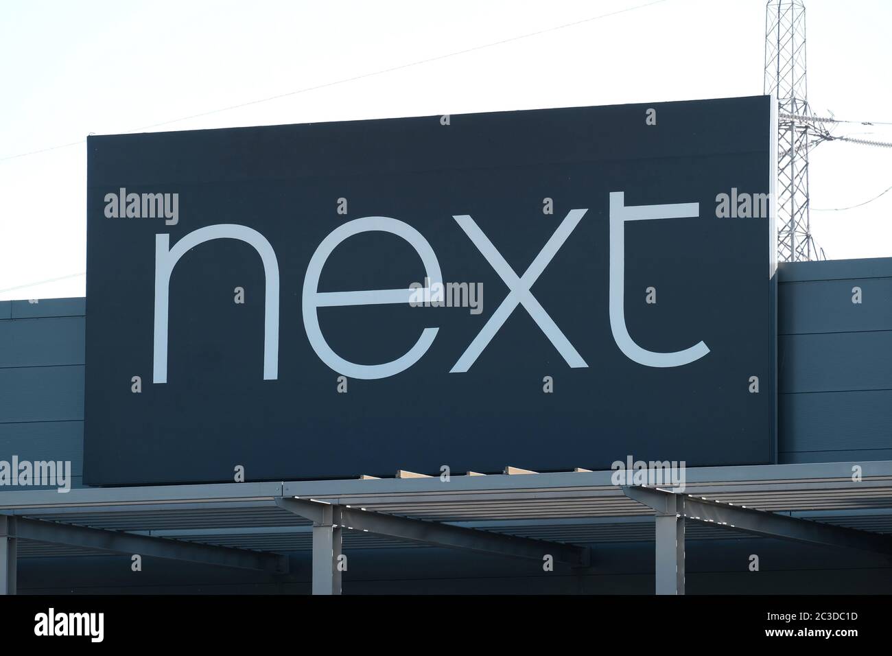 A Next sign with distinctive white lettering against a black background ...
