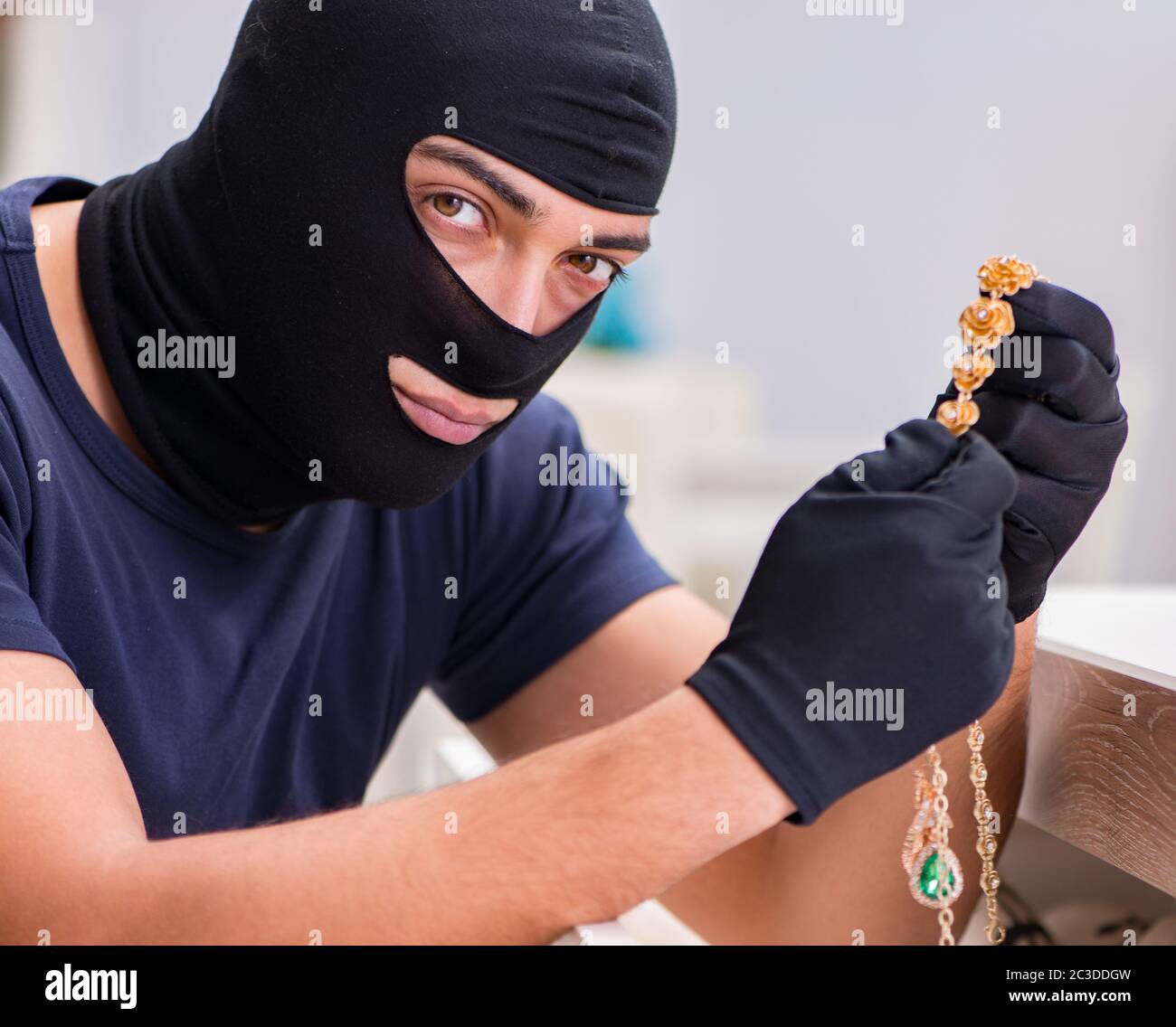 Robber wearing balaclava stealing valuable things Stock Photo - Alamy