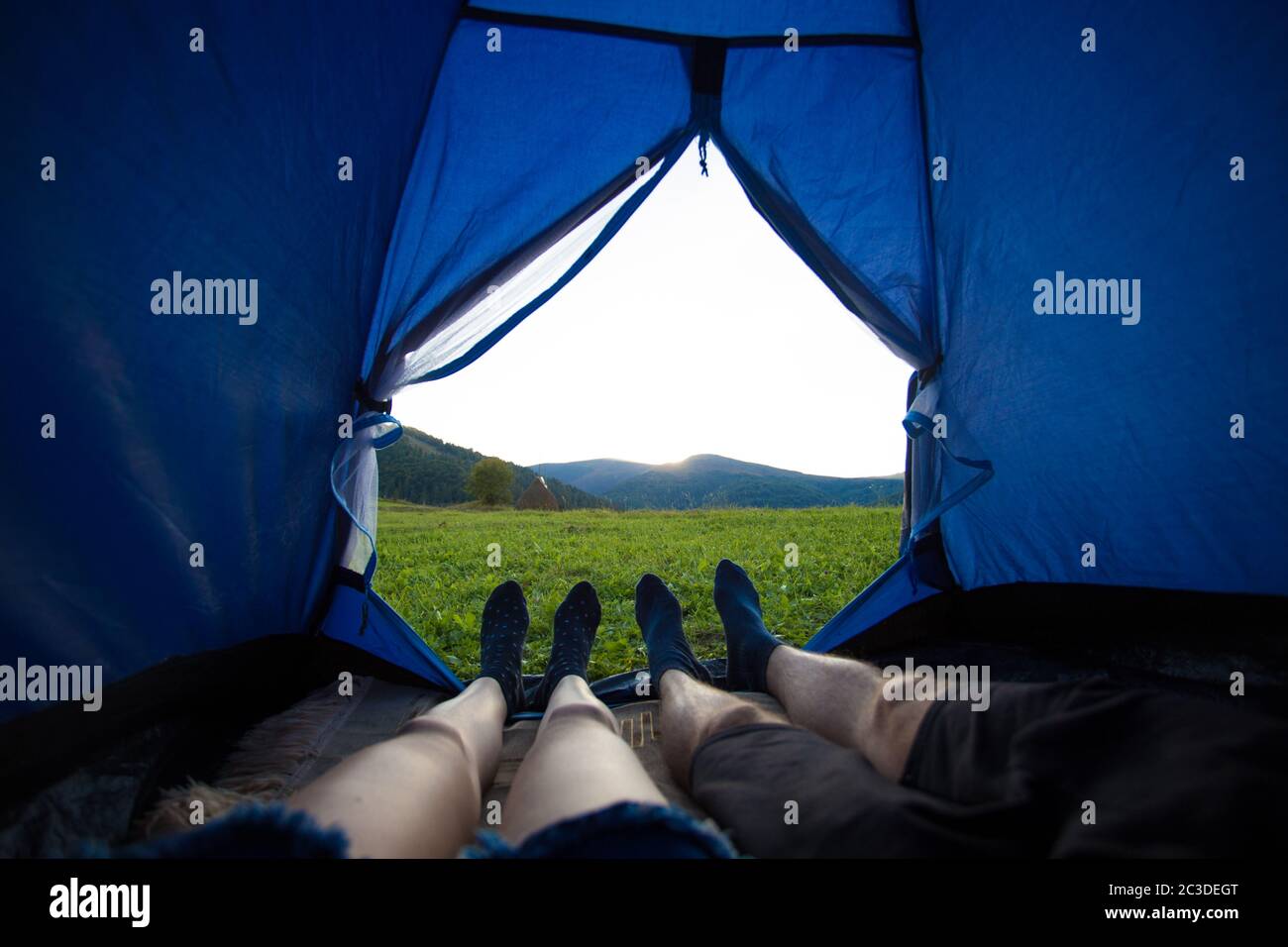 Two people lying in tent, view from inside. Couple camping with ...