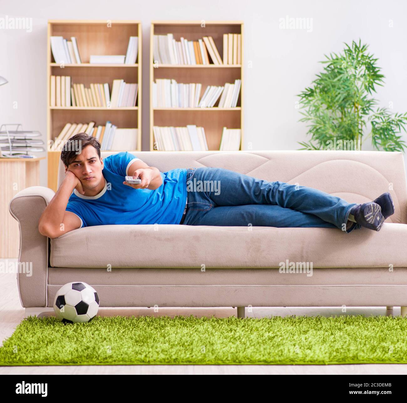 Man watching football at home sitting in couch Stock Photo - Alamy