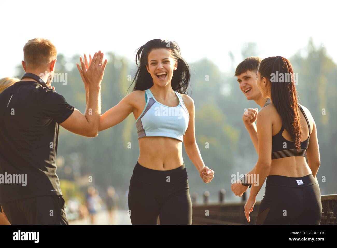 Girl runner runs fun with a group of friends in a park Stock Photo - Alamy