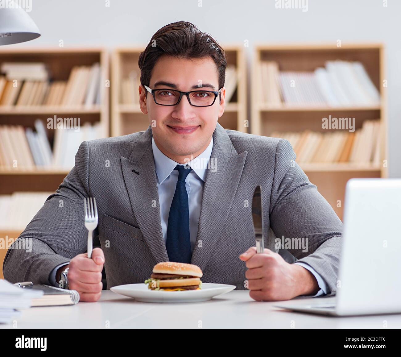 Hungry funny businessman eating junk food sandwich Stock Photo - Alamy