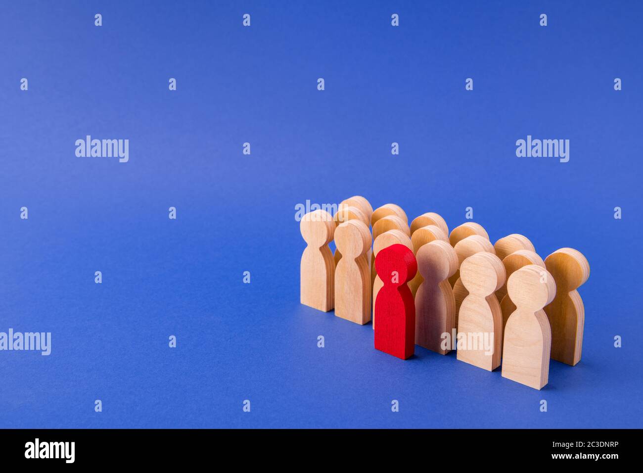 Wooden faceless figures of employees standing behind their leader ...