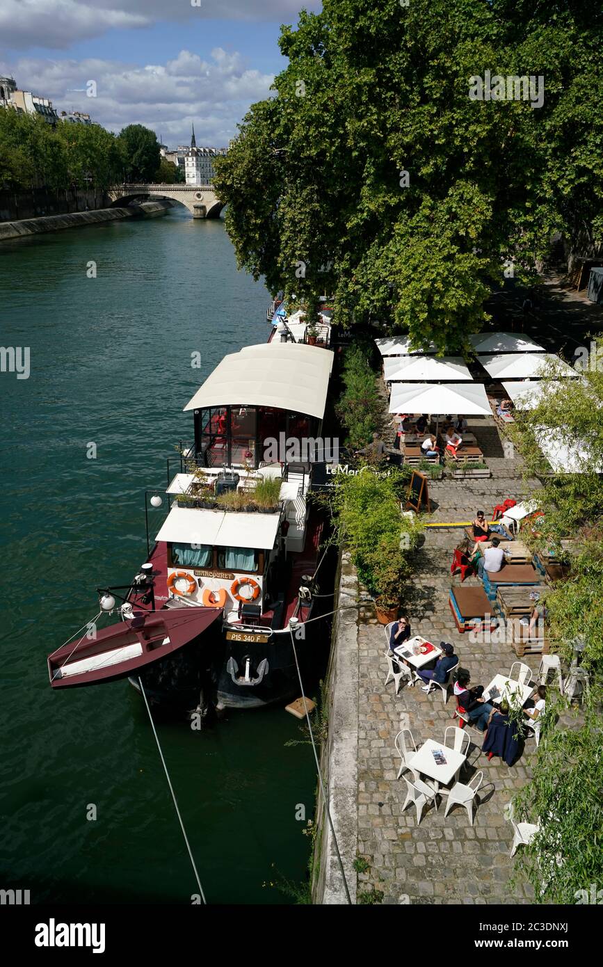A barge restaurant on Seine River with on land outdoor seating.Paris ...