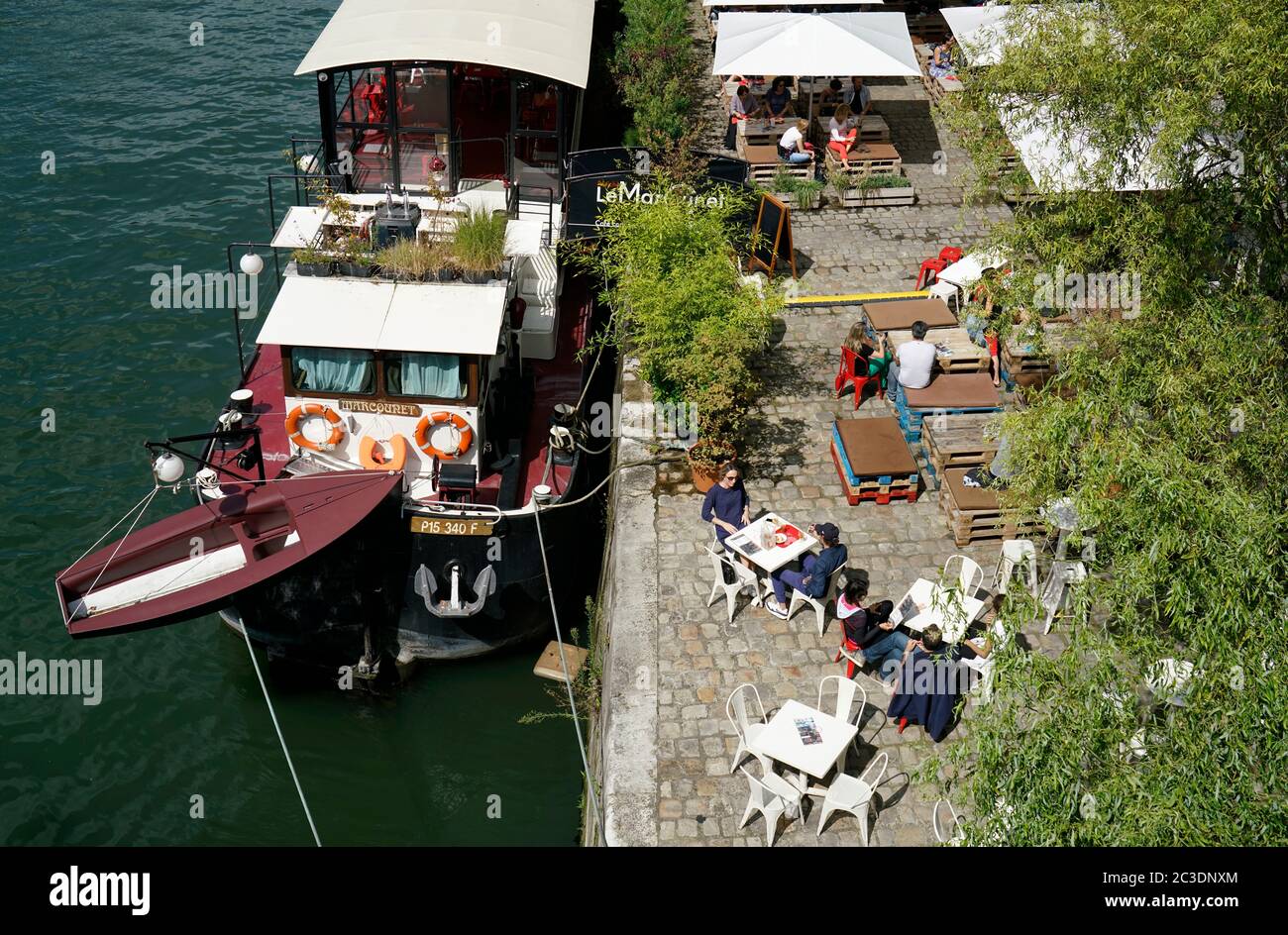 A barge restaurant on Seine River with on land outdoor seating.Paris ...