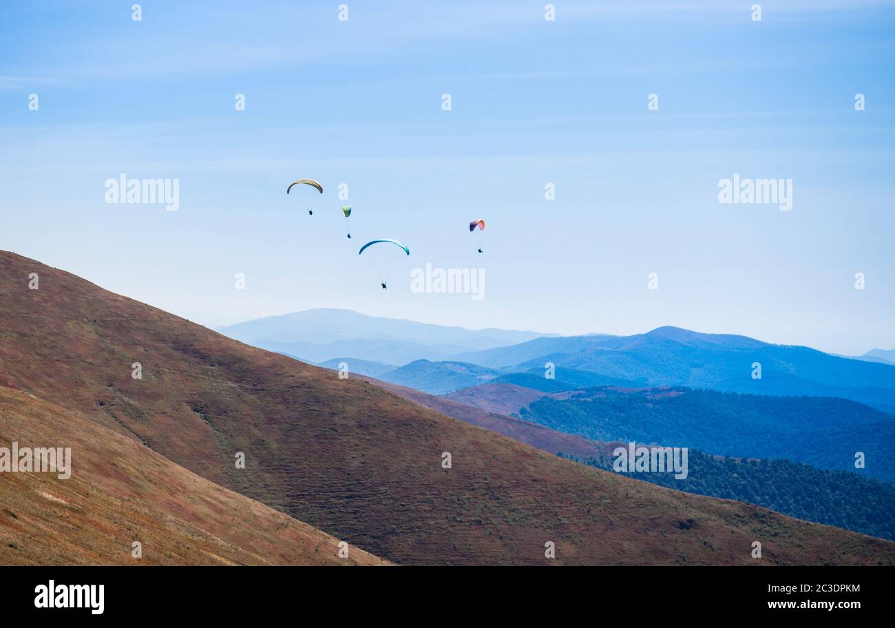 Paragliding group in air sport on top of a mountain. The whole world is ...