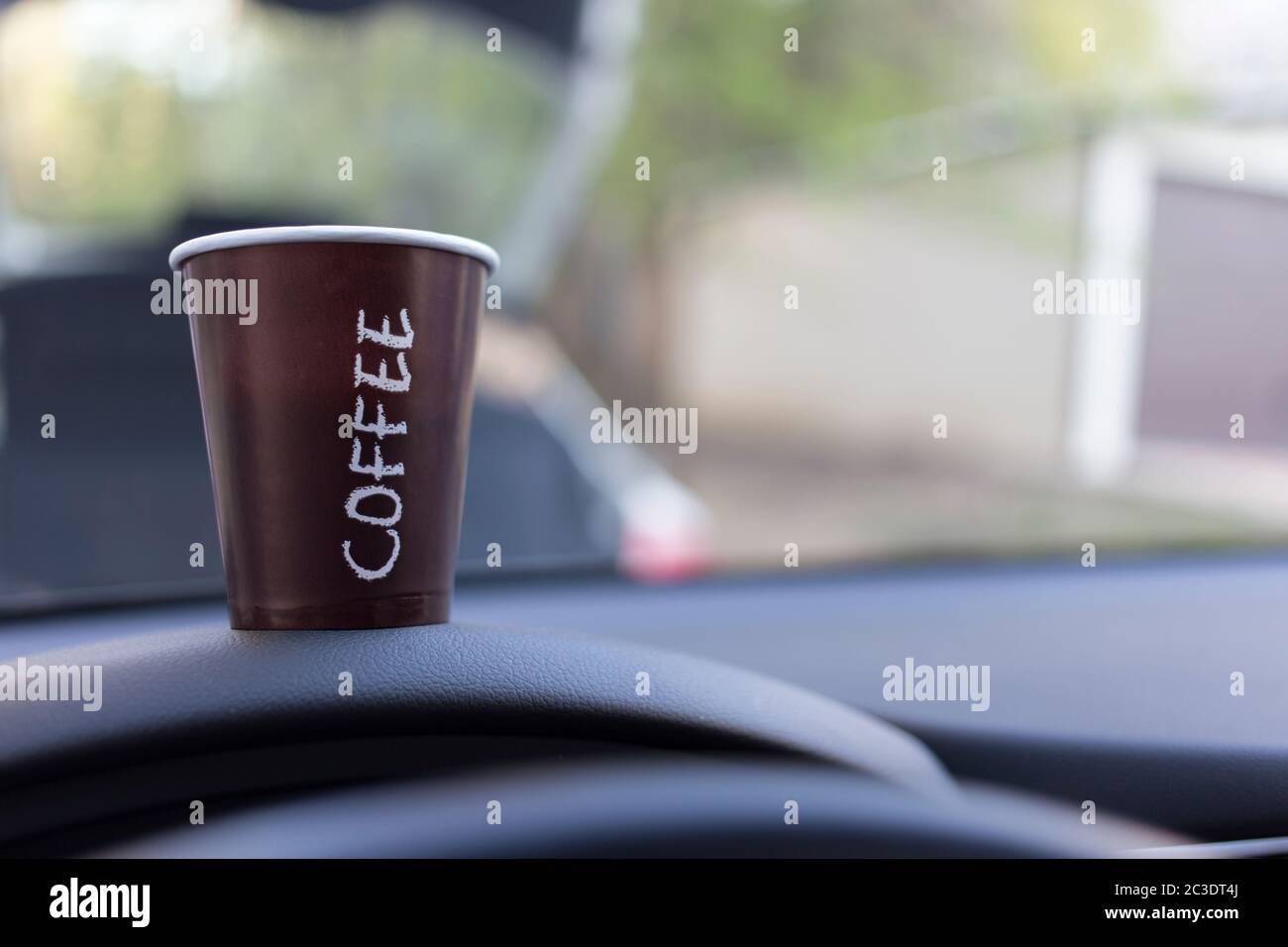 Cup of hot coffee on car console. Blurred background Stock Photo - Alamy