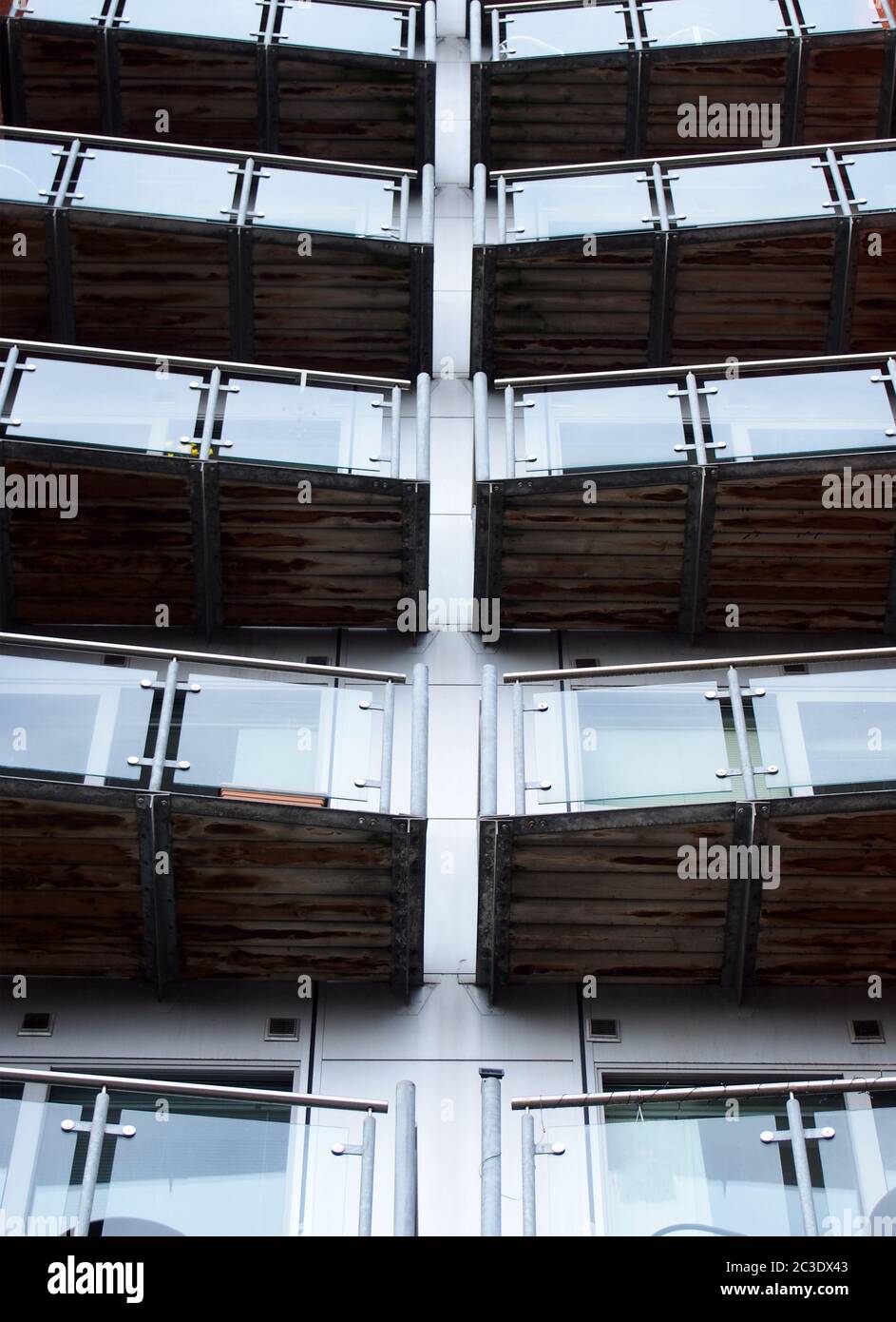 vertical perspective view of angled modern glass apartment balconies on ...