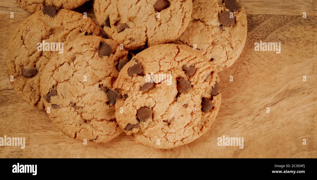 Chocolate chip cookies panorama on a rustic wooden background, toned ...
