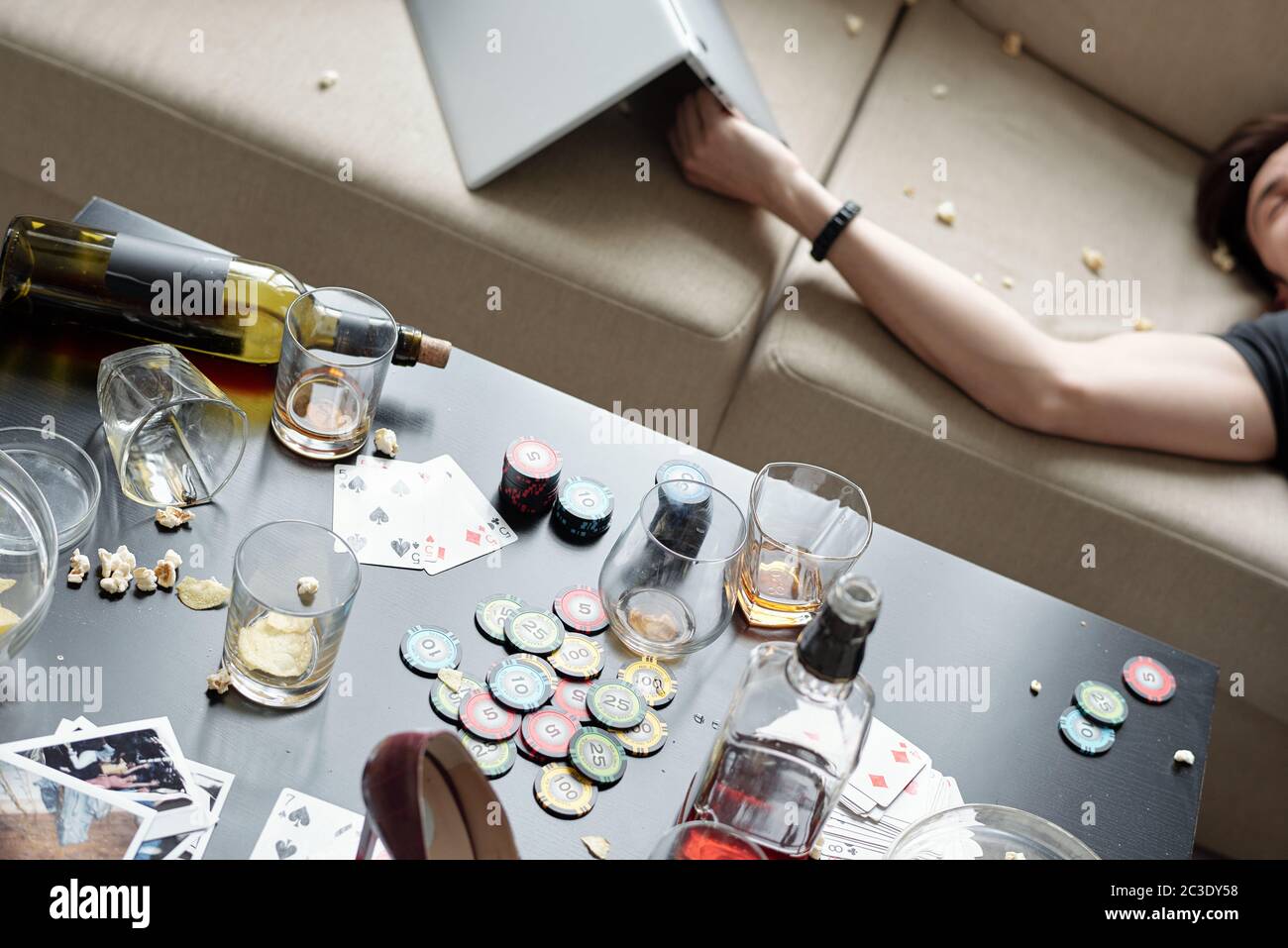 Above view of drunken man sleeping on sofa with laptop after party ...