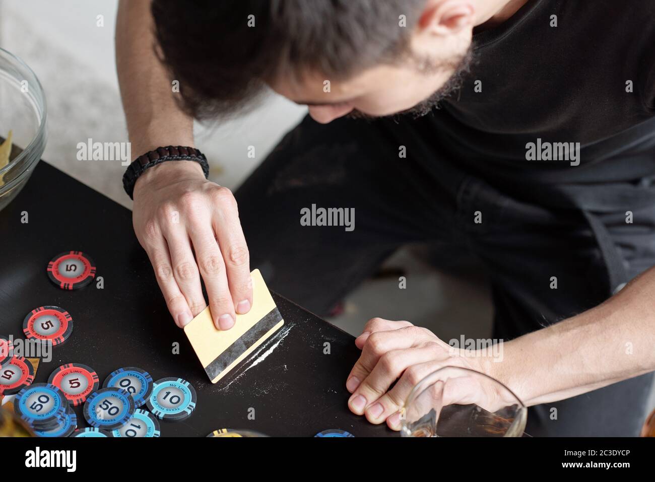 Close-up of drug addict using credit card while making powder line for ...
