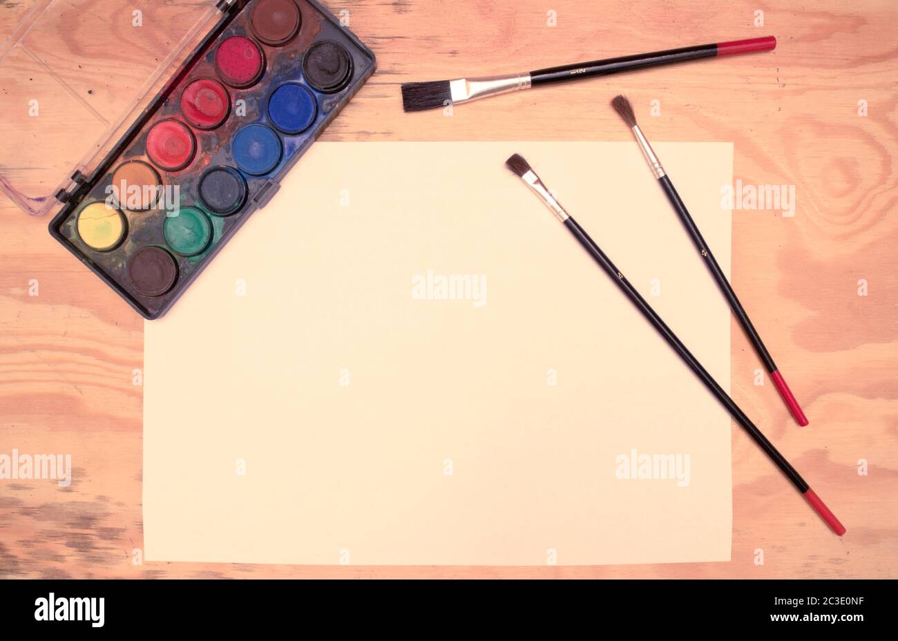 Flat lay - watercolors, paintbrushes, paper, wooden desk (vintage color ...