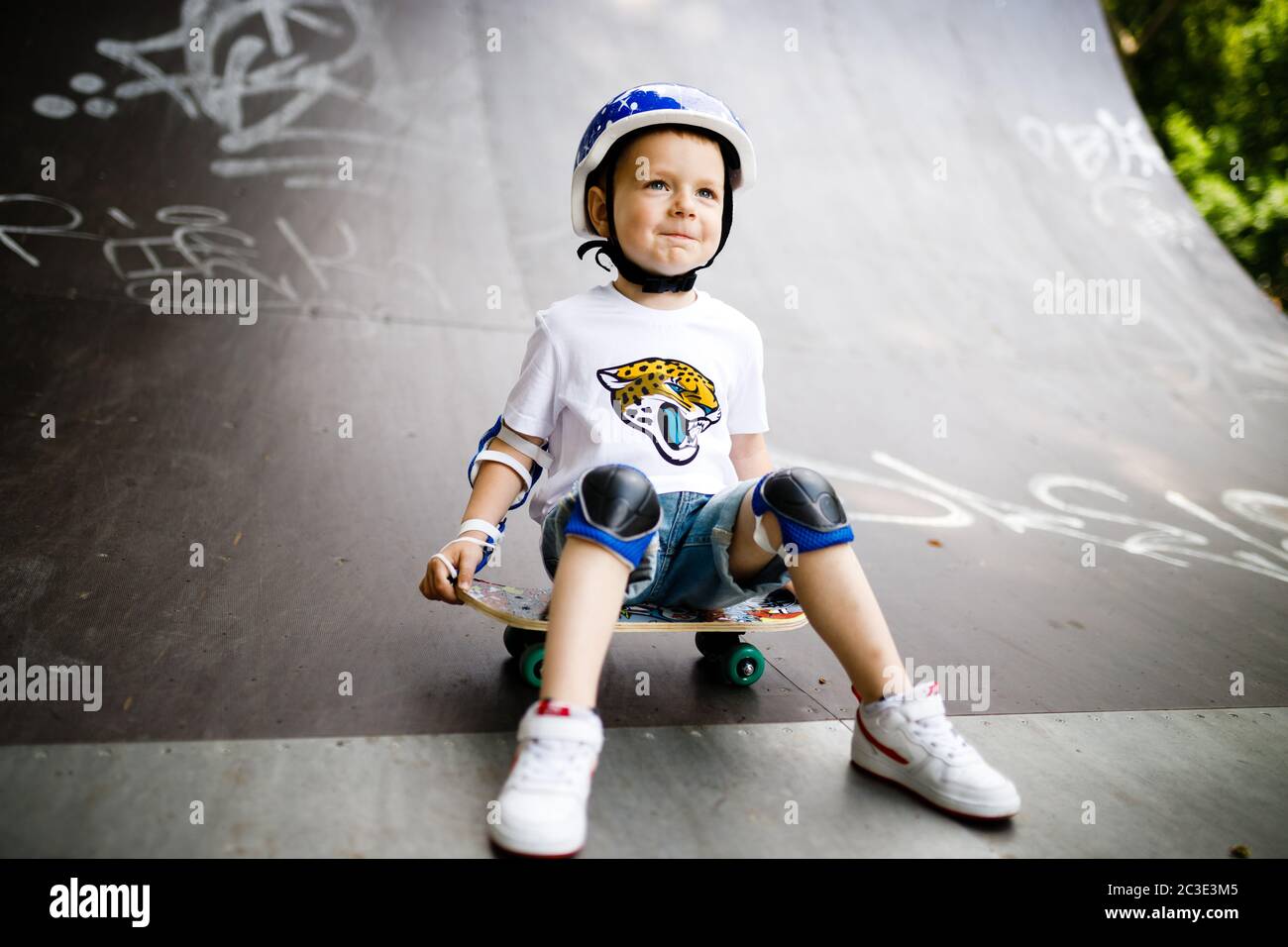 Boy with a skate in a skate park. The boy learns to skate, in full ...