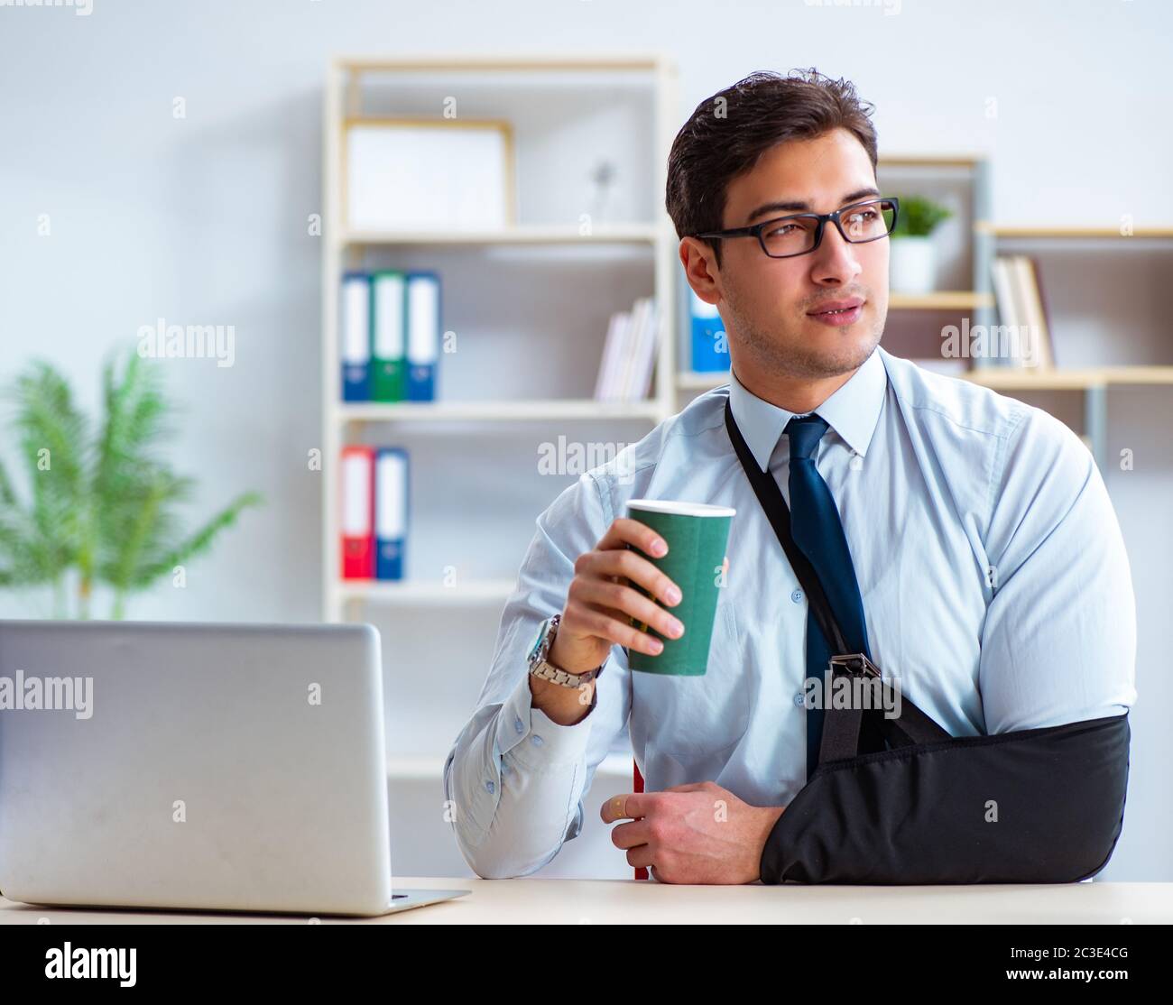 Businessman with broken arm working in office Stock Photo - Alamy