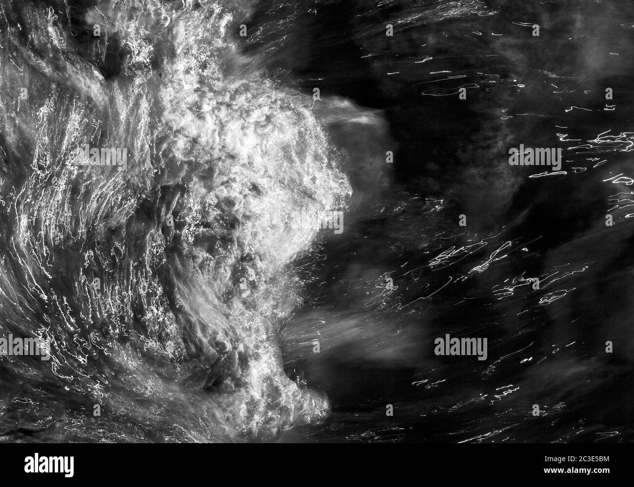 Detail view of flowing water, sun reflexes showing the direction of the ...