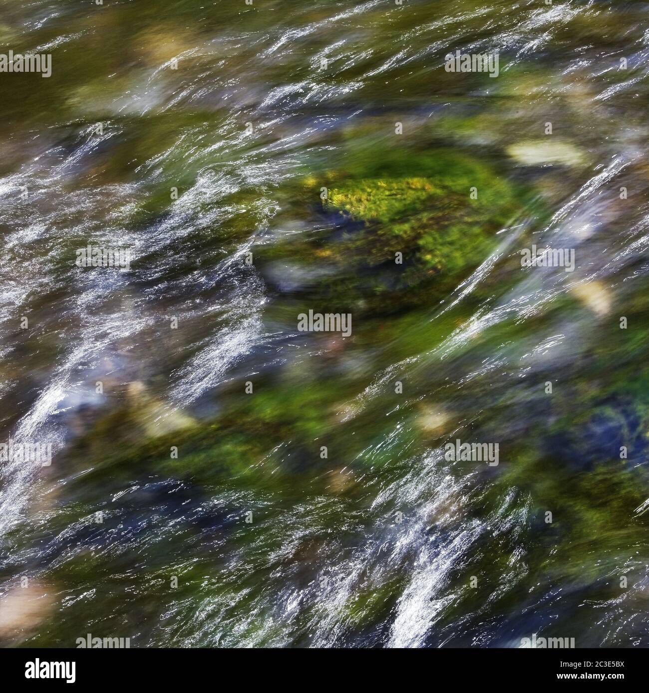 Detail view of flowing water, sun reflexes showing the direction of the ...