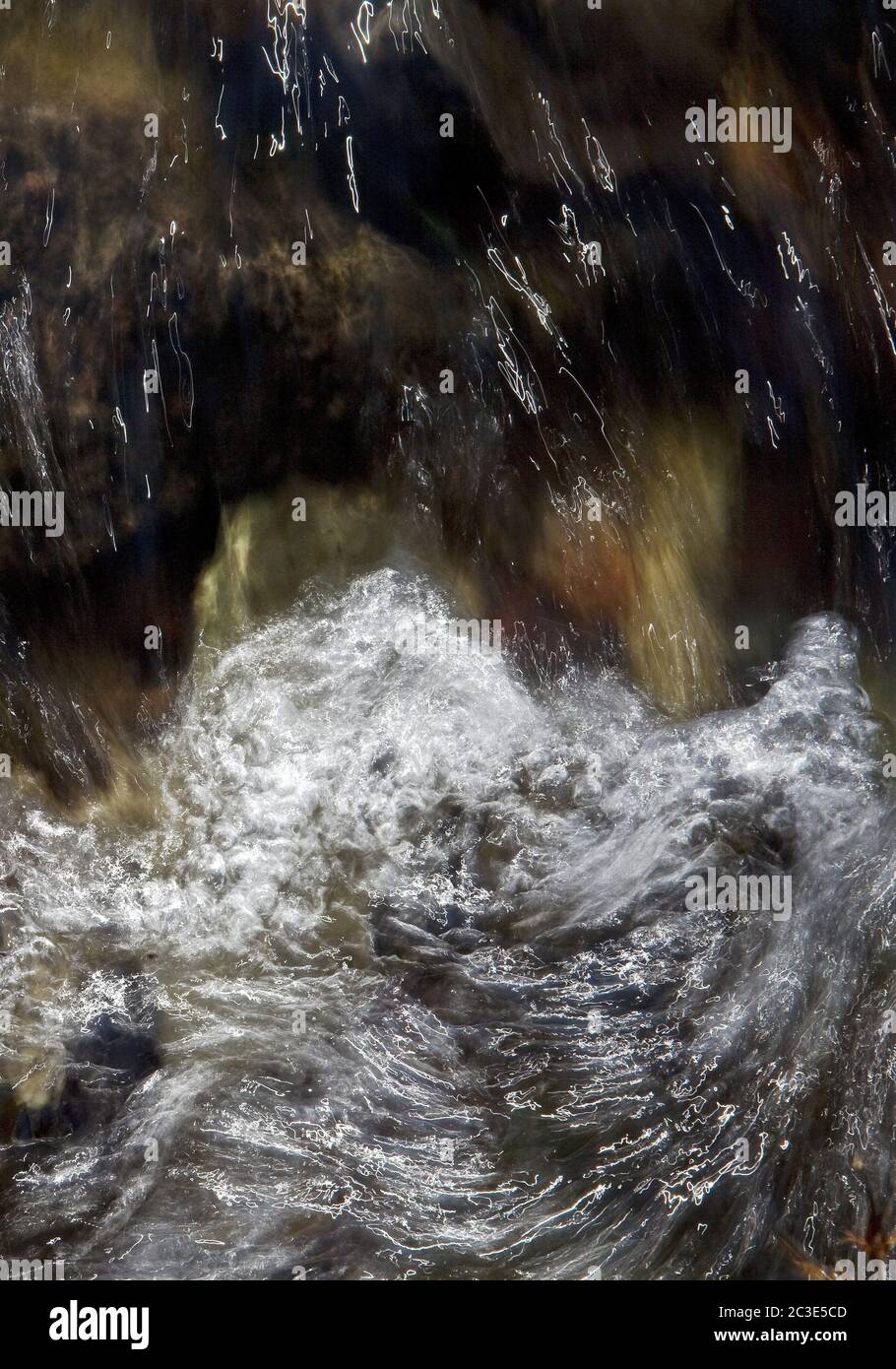 Detail view of flowing water, sun reflexes showing the direction of the ...
