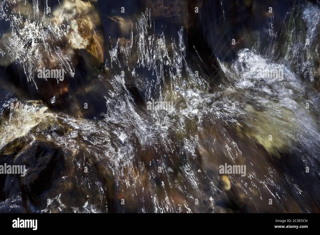 Detail view of flowing water, sun reflexes showing the direction of the ...