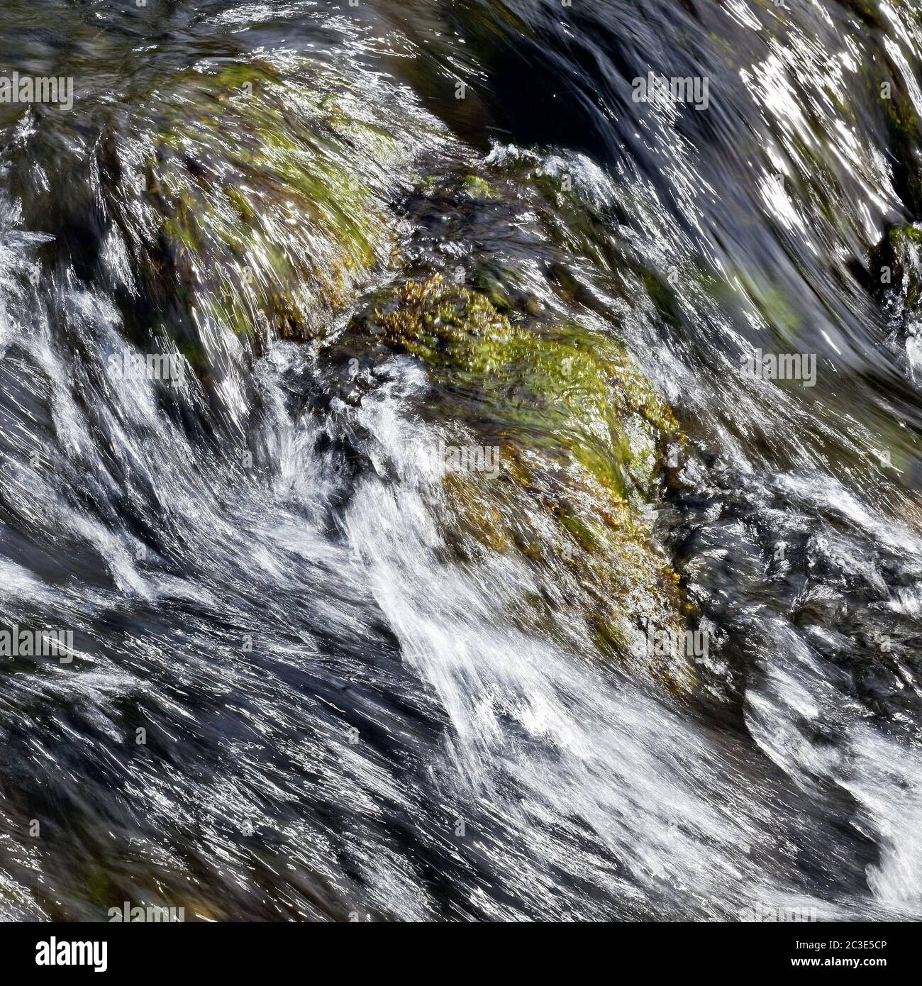 Detail view of flowing water, sun reflexes showing the direction of the ...
