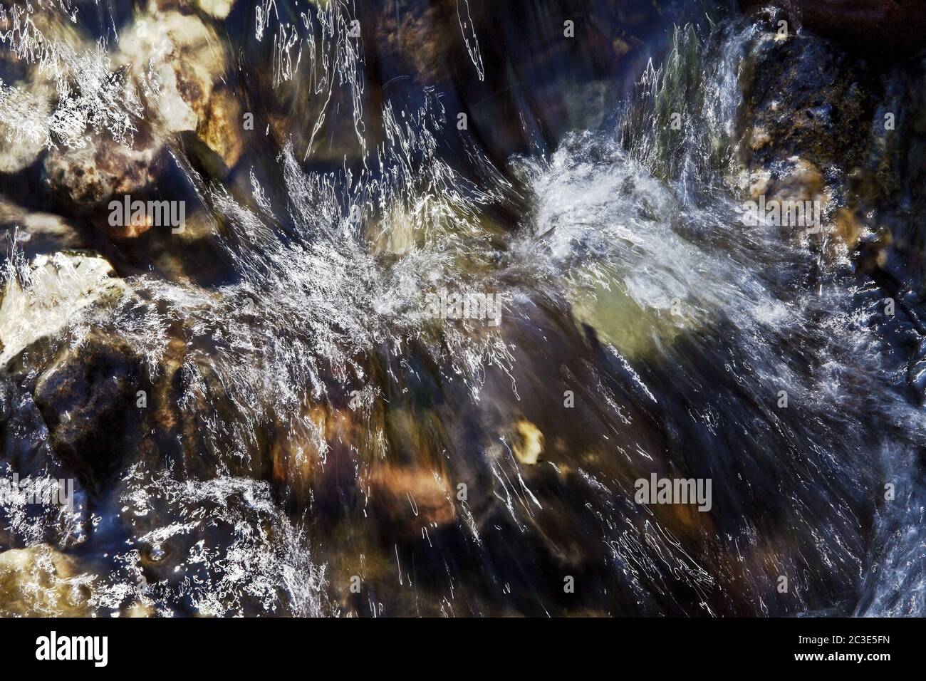 Detail view of flowing water, sun reflexes showing the direction of the ...