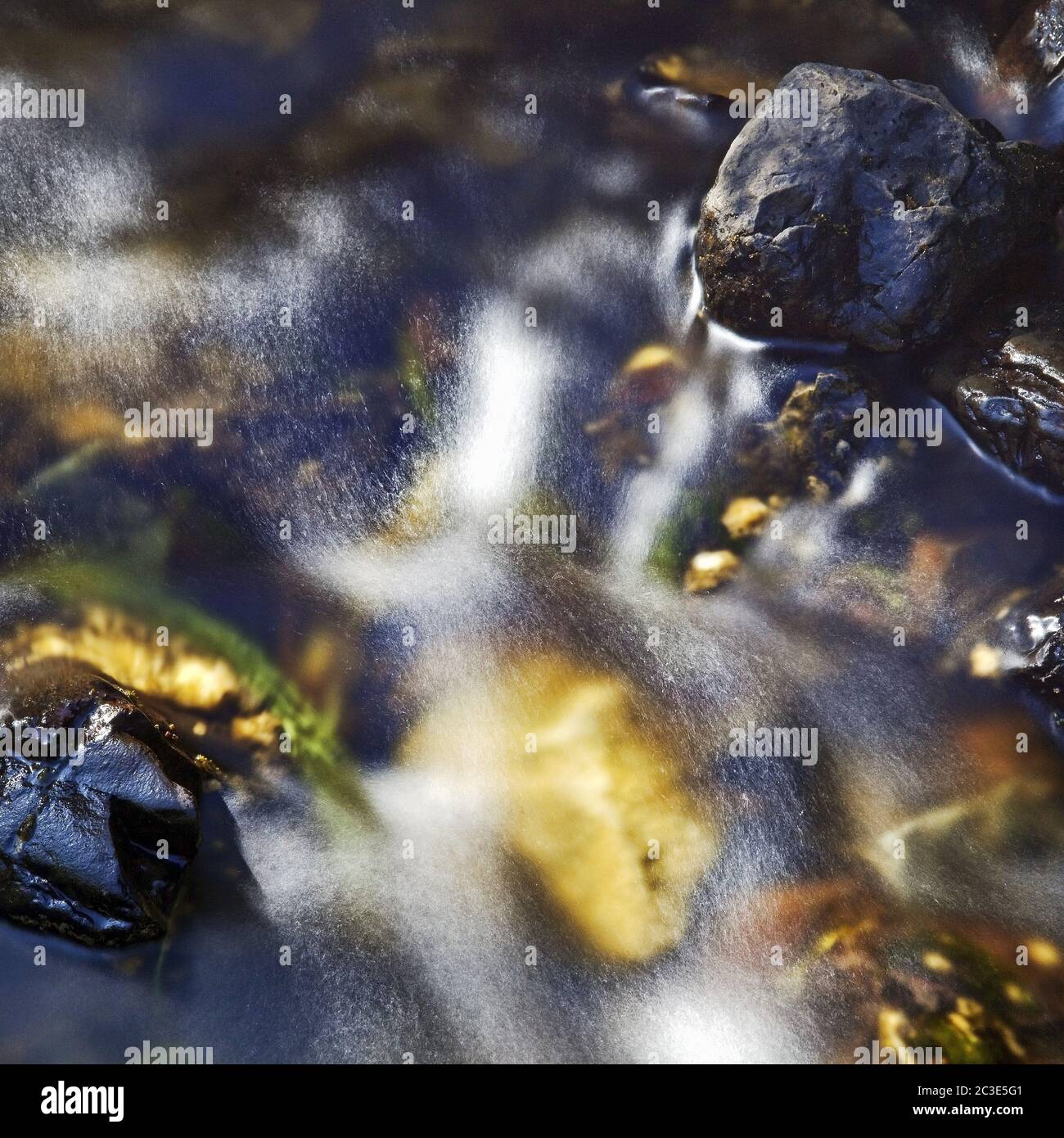 Detail view of flowing water, sun reflexes showing the direction of the ...