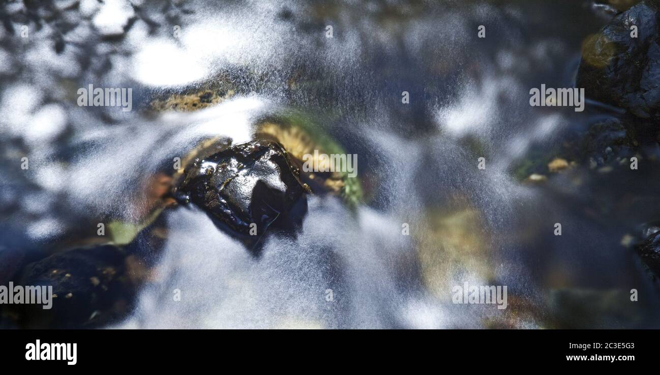 Detail view of flowing water, sun reflexes showing the direction of the ...