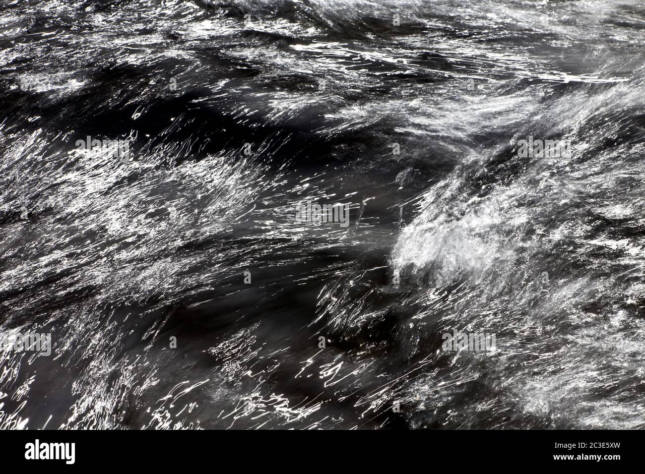 Detail view of flowing water, sun reflexes showing the direction of the ...