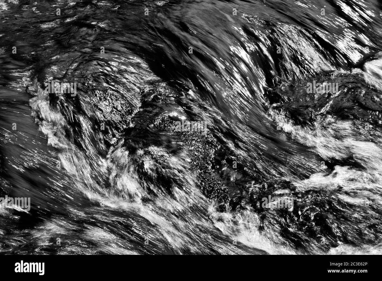 Detail view of flowing water, sun reflexes showing the direction of the ...