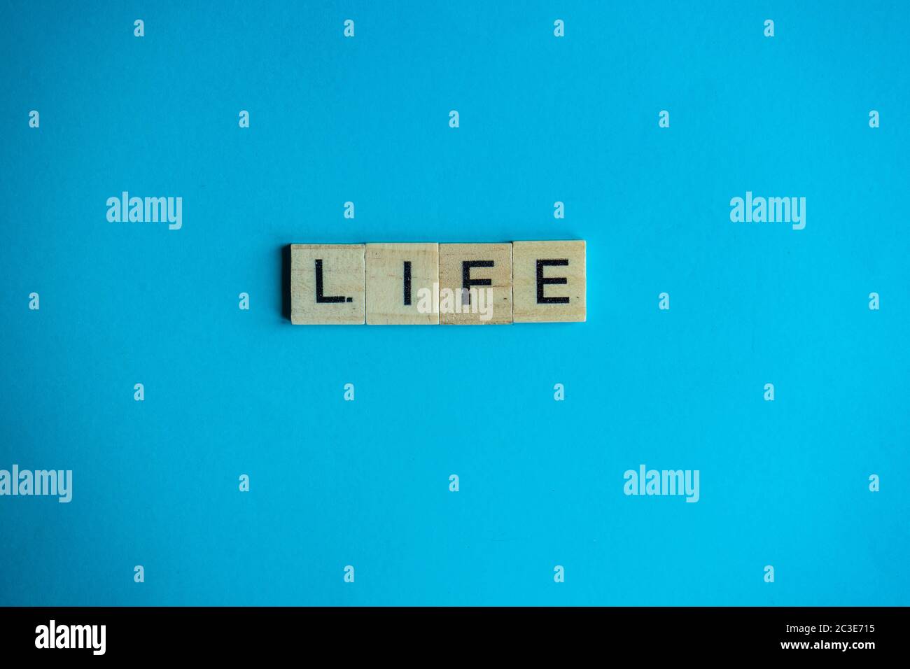 Wooden blocks with LIFE words on blue background Stock Photo - Alamy