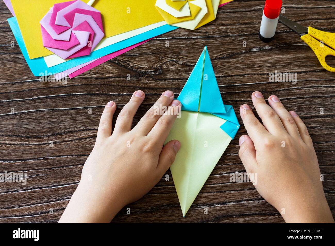 Instruction step 9. Funny toy Origami paper ice cream on a wooden table ...