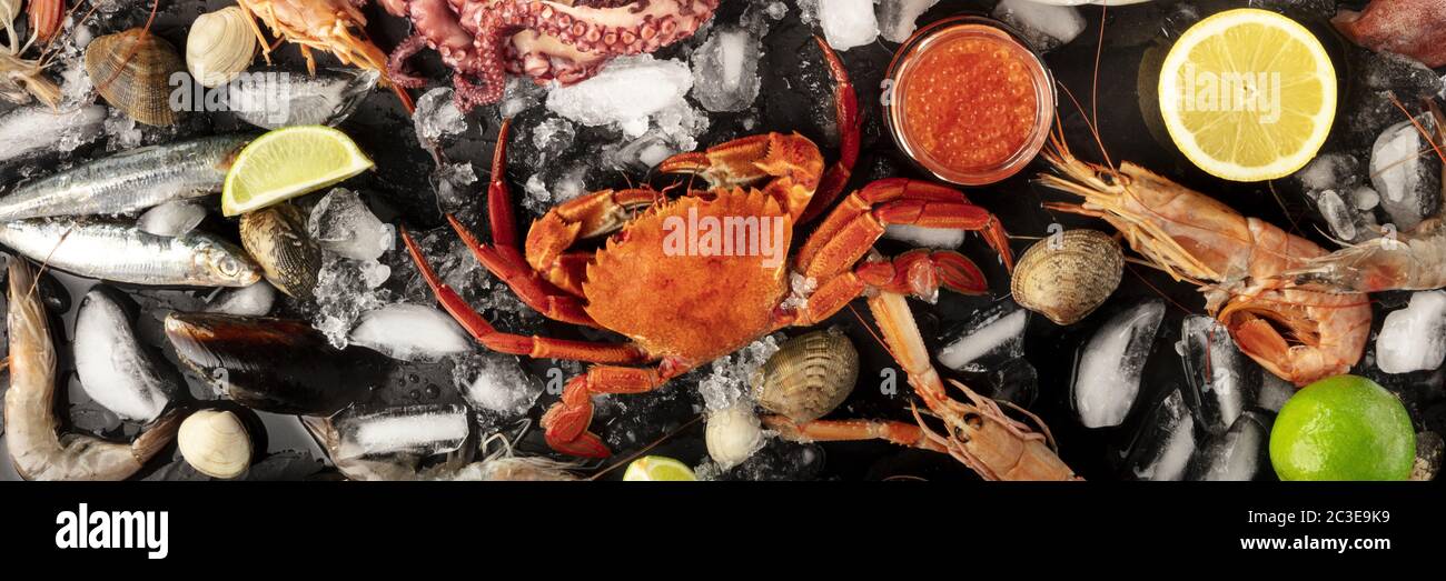 Crab with fish, shrimps, and caviar, overhead seafood panorama on a ...