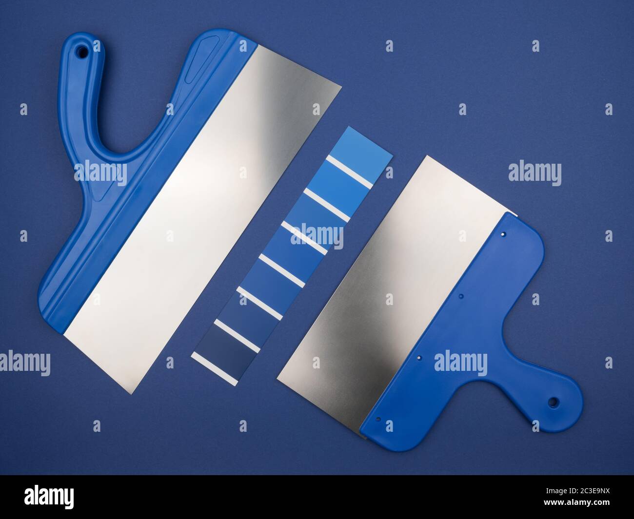 Blue spatula on a blue background. Blue still life with repair tool and ...