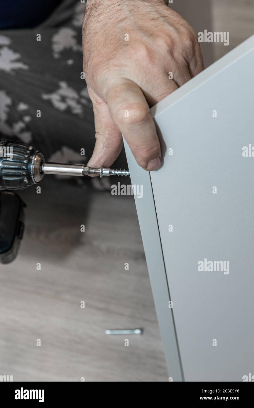 master builds a furniture Cabinet. Mounting for furniture panels ...