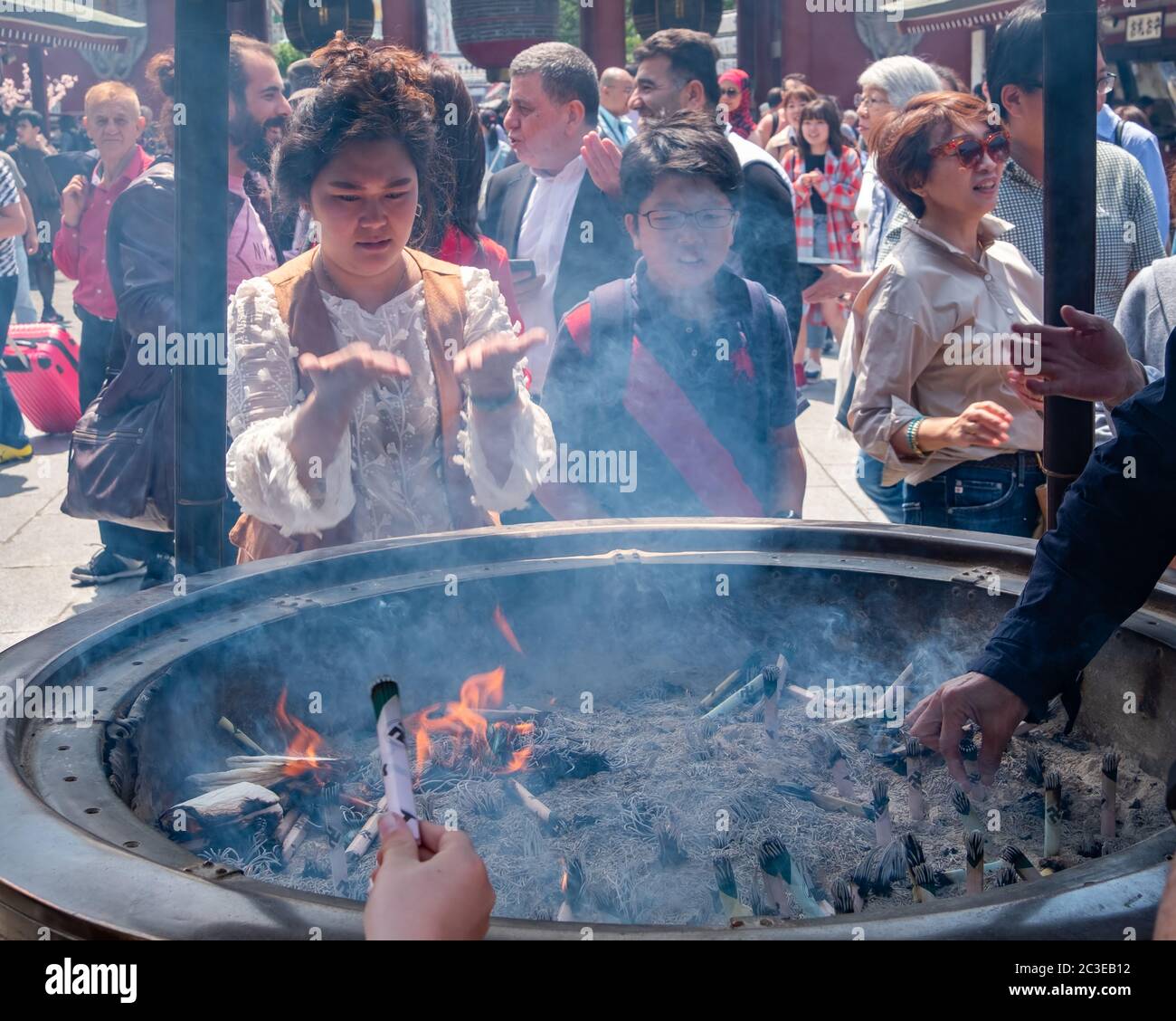 Tourist drawing smoke (believe to have healing properties) from Jokoro ...
