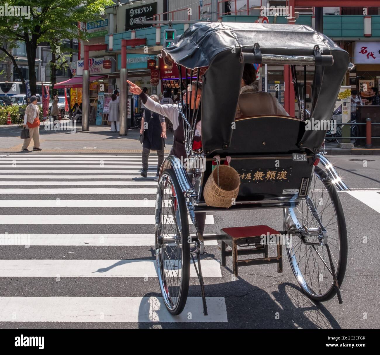 Rickshaw puller with tourists in the street of Asakusa, Tokyo, Japan ...