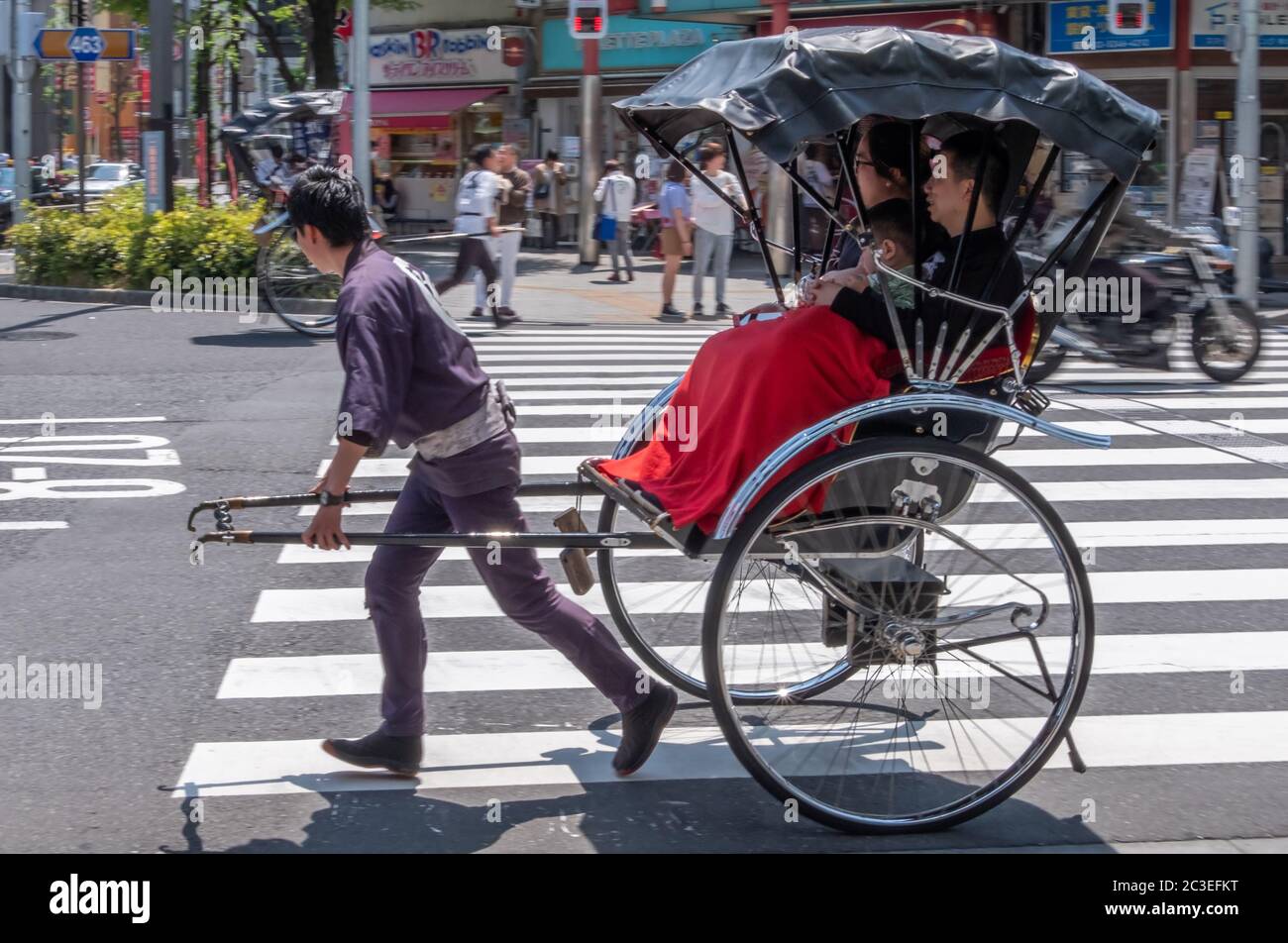 Rickshaw puller with tourists in the street of Asakusa, Tokyo, Japan ...